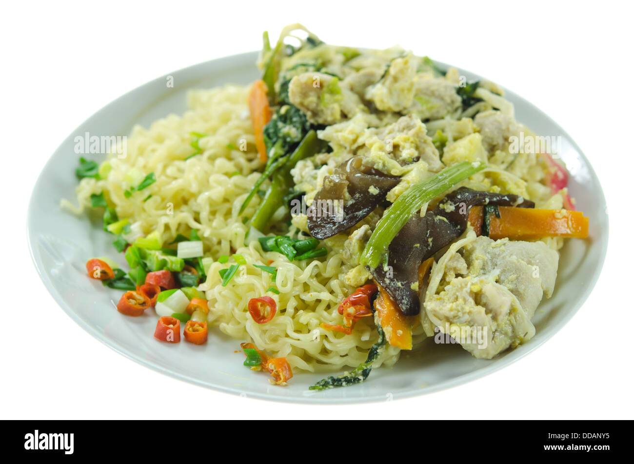 cooked instant noodles with chili and vegetable on dish over white ...