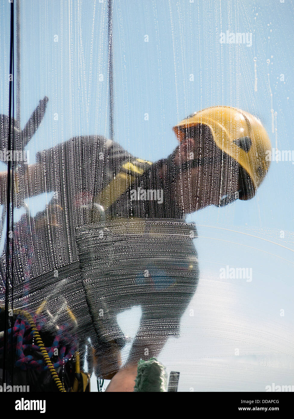 Window cleaners working on high rise tower block abseiling on the ...
