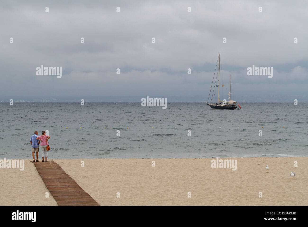 A couple watch the ocean in the Spanish Mallorca´s beach of Magaluf ...