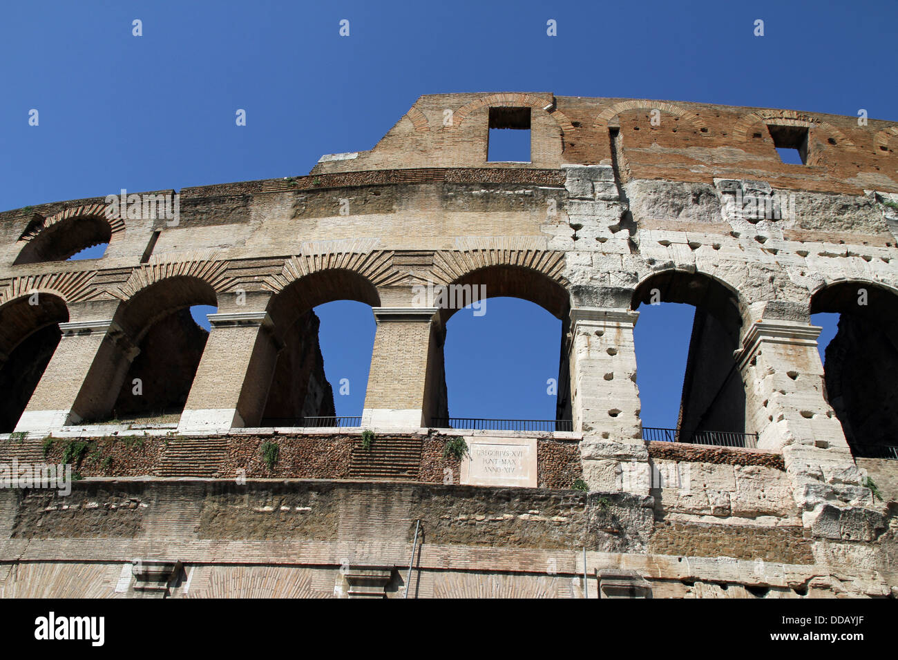 detail of an ancient Arch of the Colosseum in Rome Italy and blue sky ...