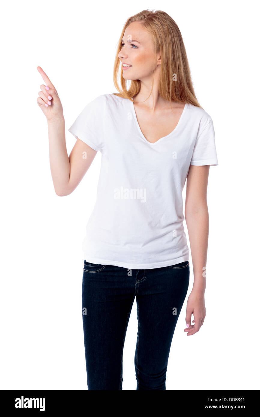 Beautiful young blond woman standing pointing and turning to look at ...