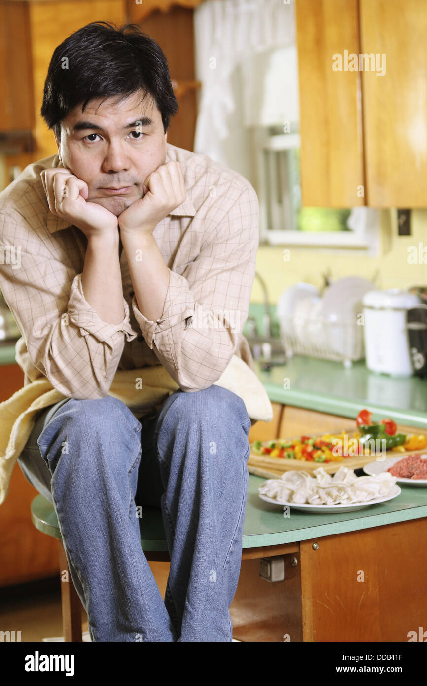 Man sitting on kitchen counter depressed with dinner ready Stock Photo ...
