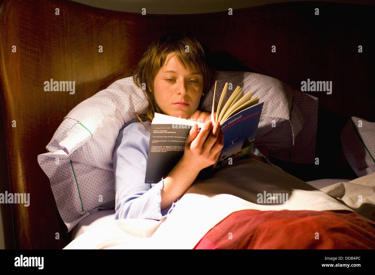 A young women read a book in the bed Stock Photo - Alamy