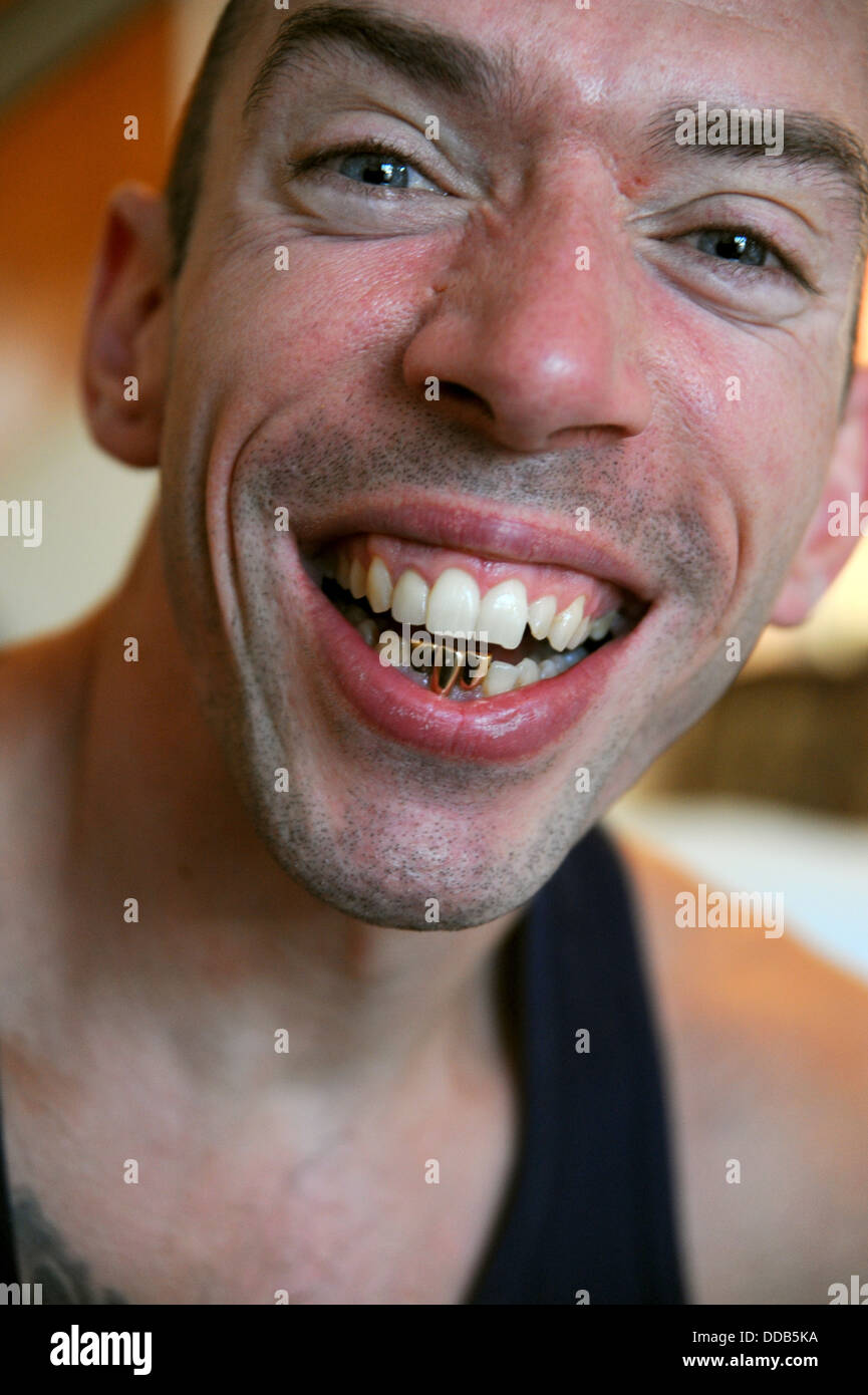 Portrait of young man smiling with 3 gold teeth showing he is former ...