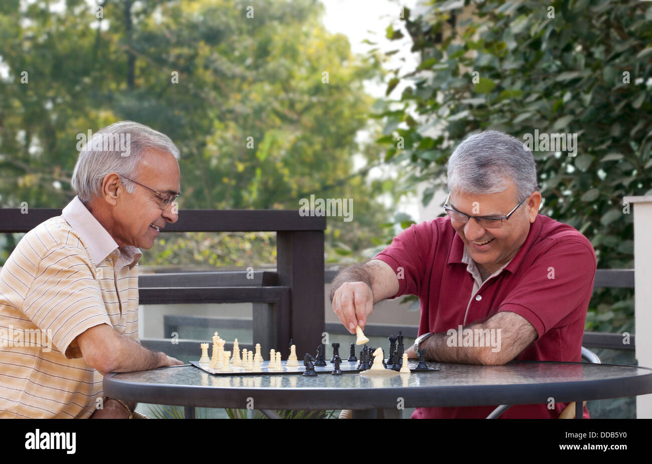 Happy senior men playing chess together Stock Photo - Alamy