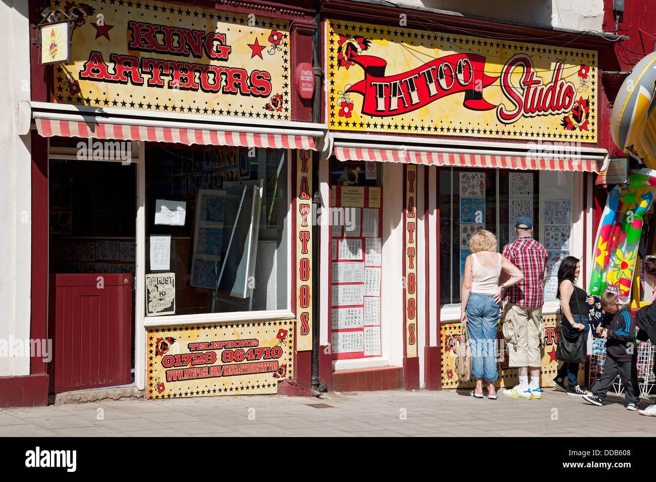 People looking in window of tattoo tattooist shop store exterior ...