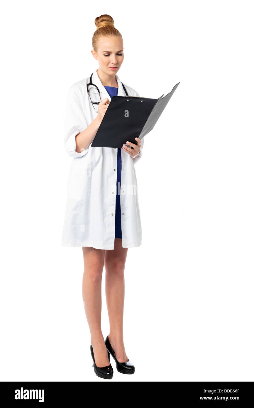 Female doctor standing reading a file of patient records while going on ...