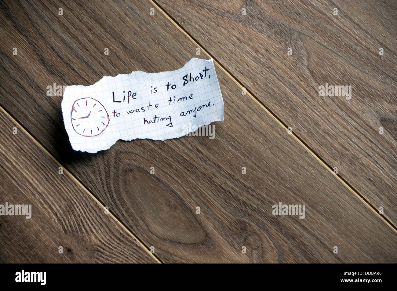 Motivational message,written on piece of paper, on a wood background ...