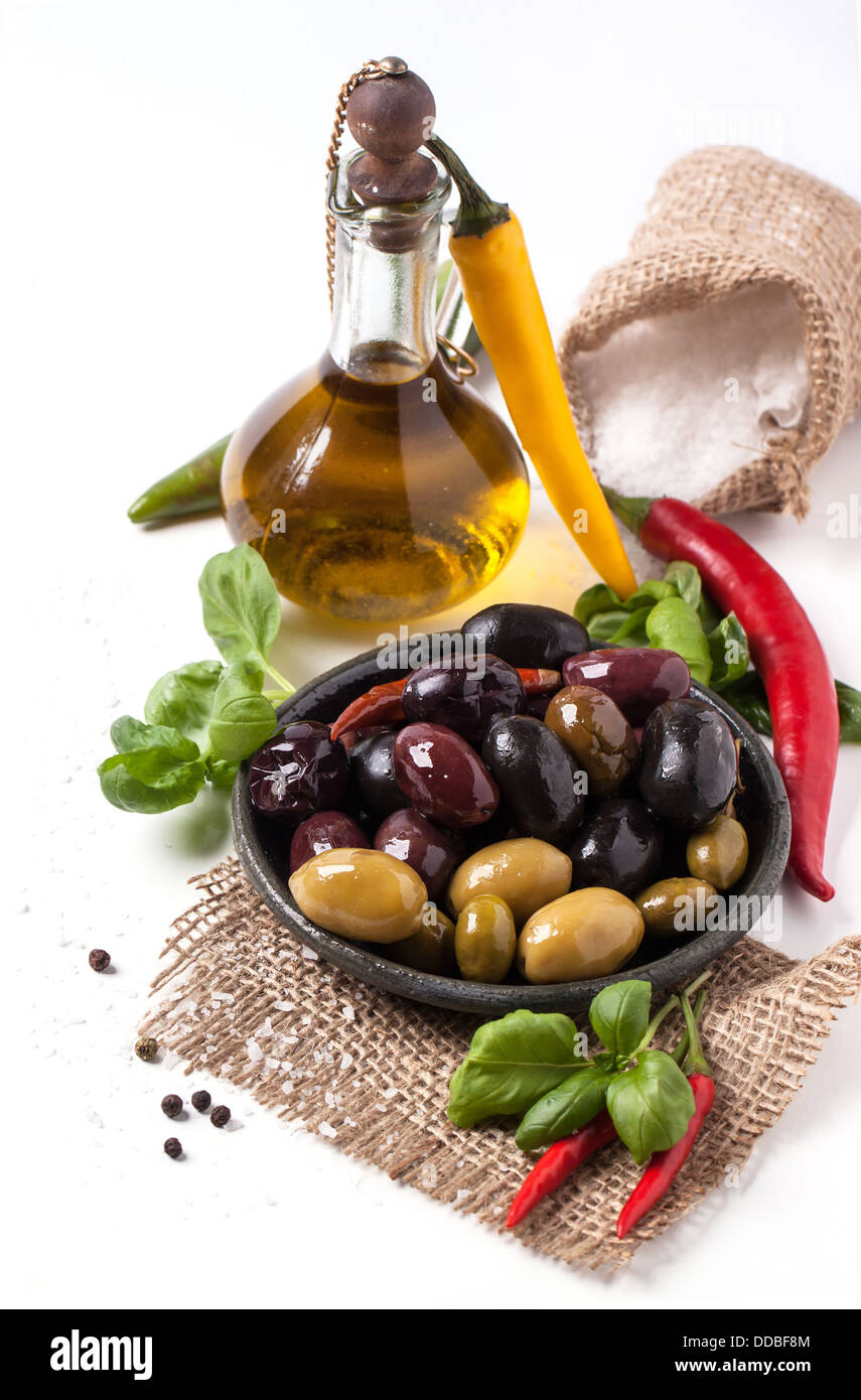 Plate of black and green olives with red hot chili peppers, basil and ...