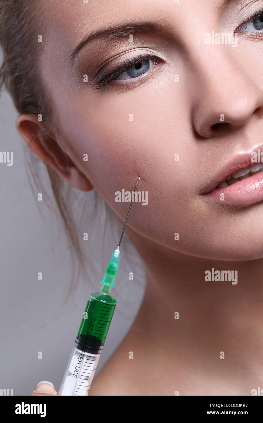 Beautiful woman gets an injection in her face Stock Photo - Alamy