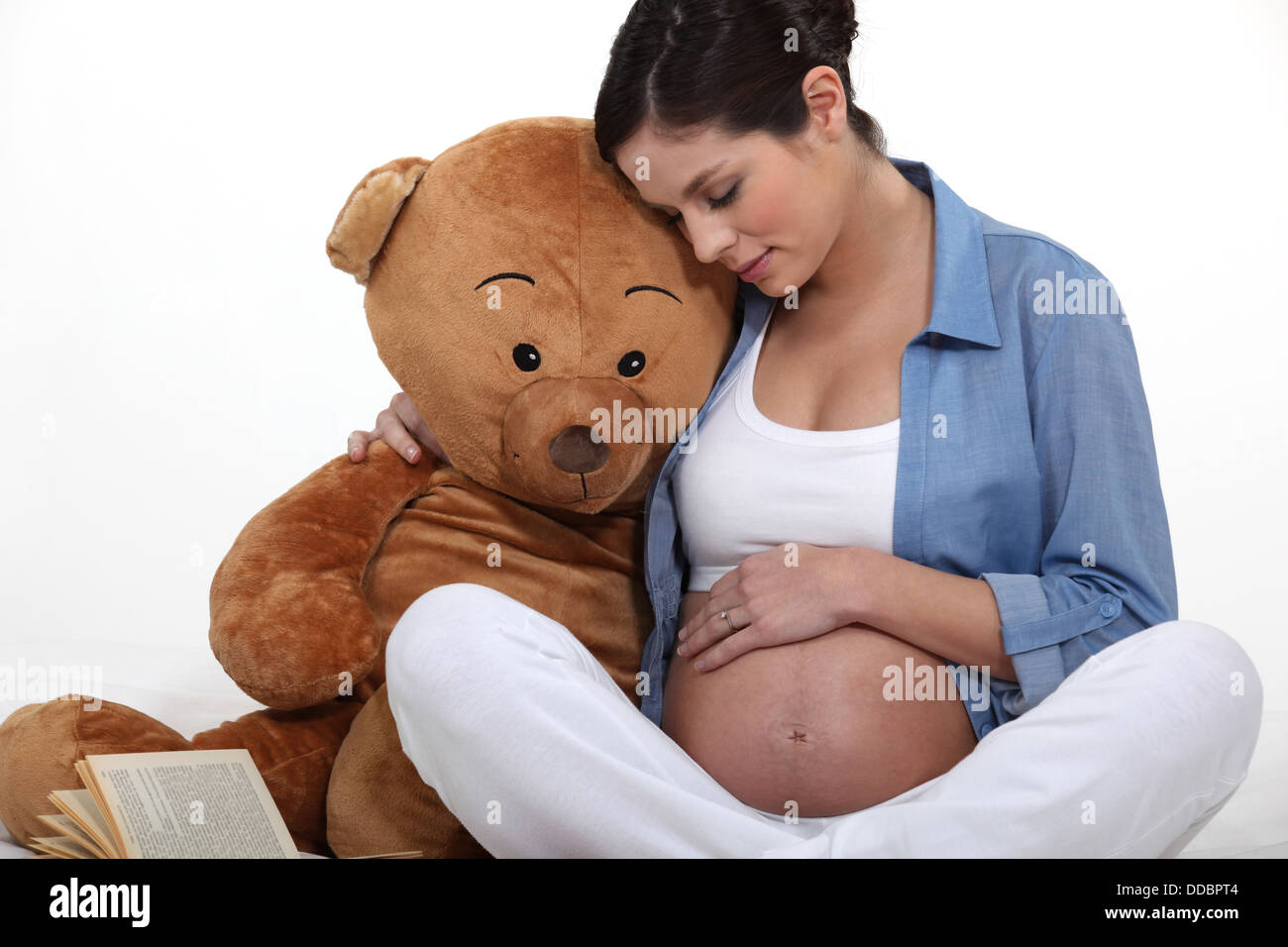 Pregnant woman sat with large teddy bear Stock Photo - Alamy