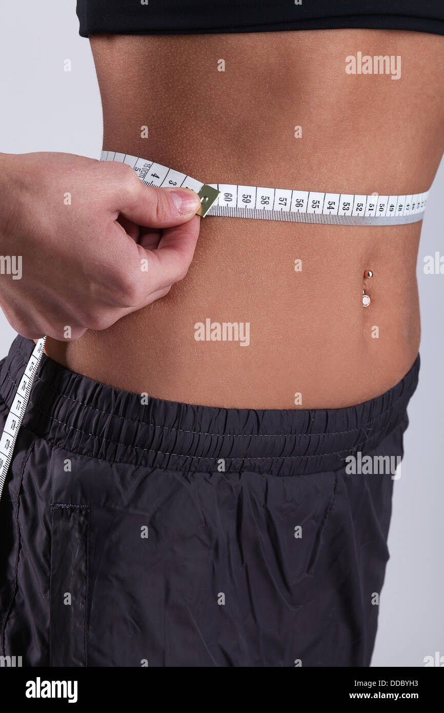 Slim blonde stomach measuring waist with ruler Stock Photo - Alamy