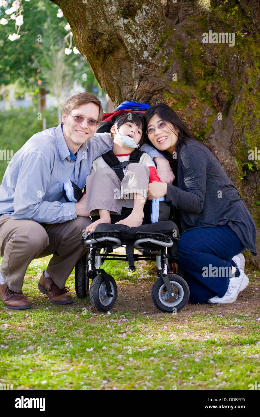 Disabled child surrounded by parents Stock Photo - Alamy