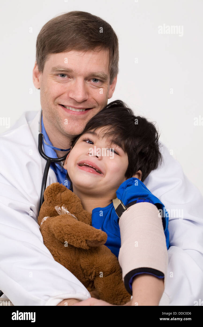 Male doctor comforting disabled toddler patient on lap Stock Photo - Alamy