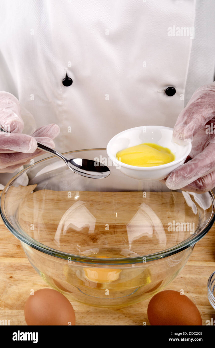 female chef holds a small bowl with mustard Stock Photo - Alamy