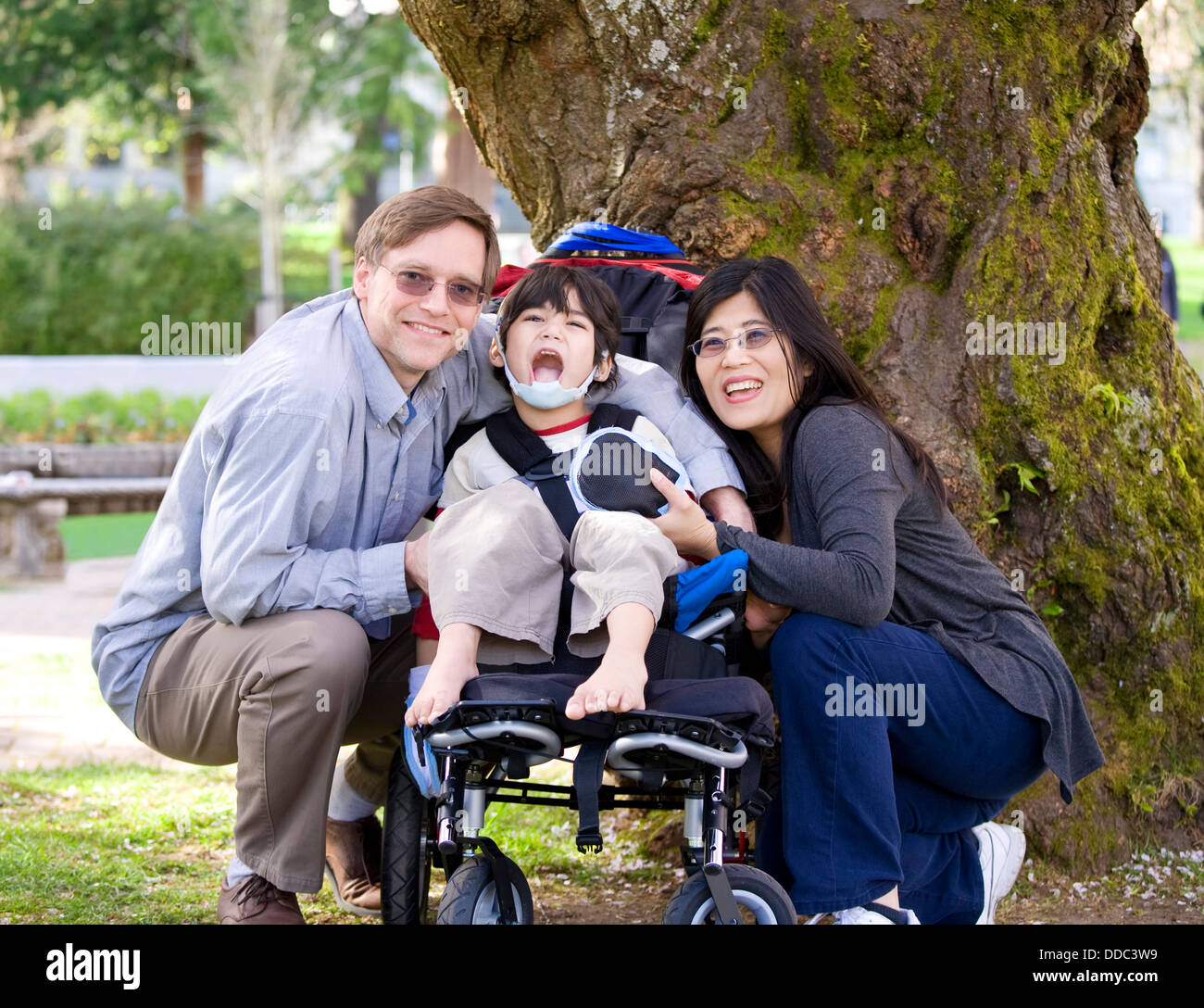Disabled child surrounded by parents Stock Photo - Alamy