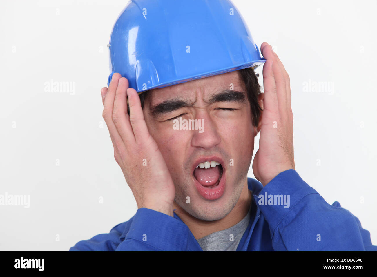 Worker hearing unbearable noise Stock Photo - Alamy