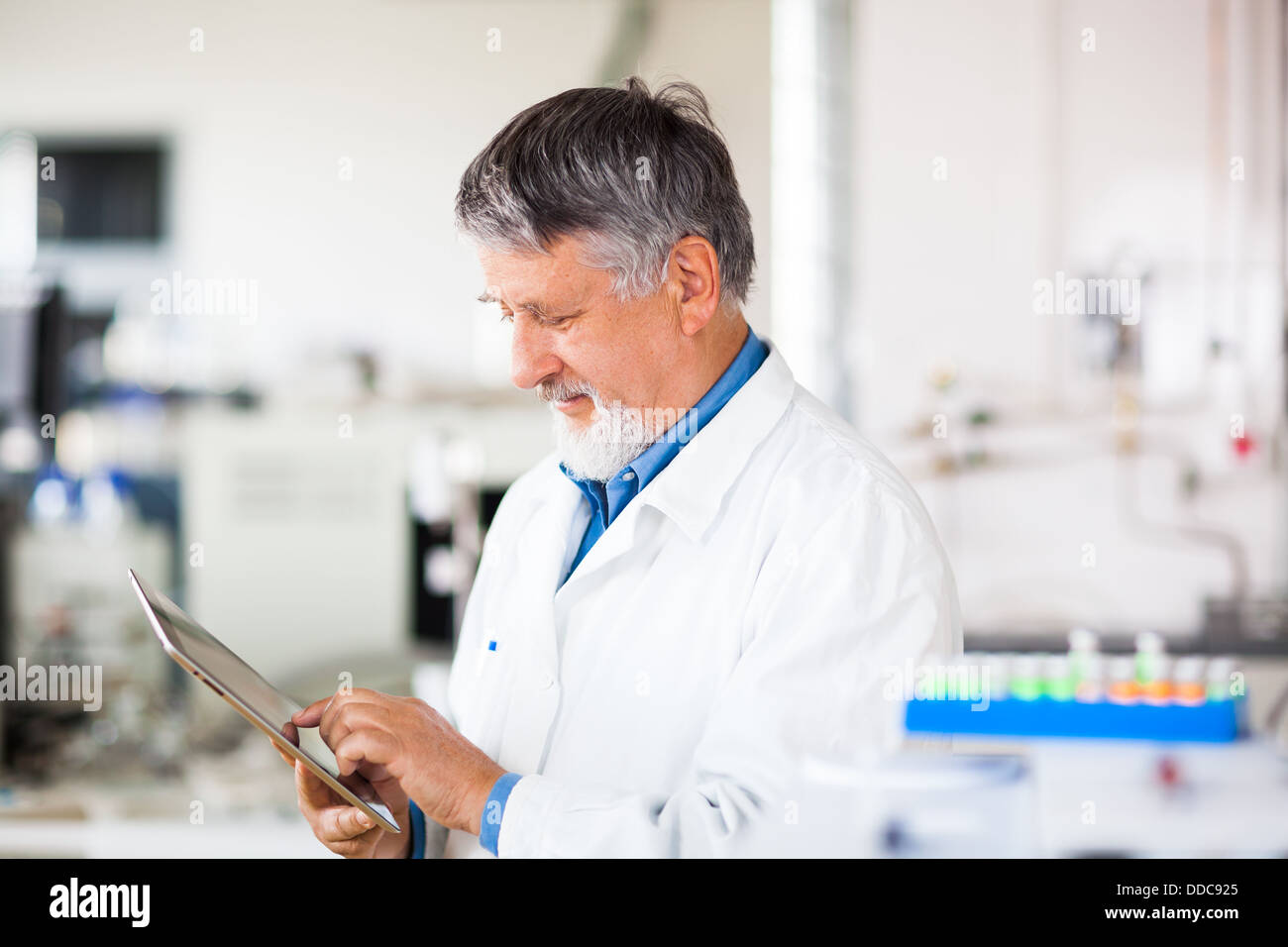 Senior doctor/scientist using his tablet computer at work Stock Photo ...