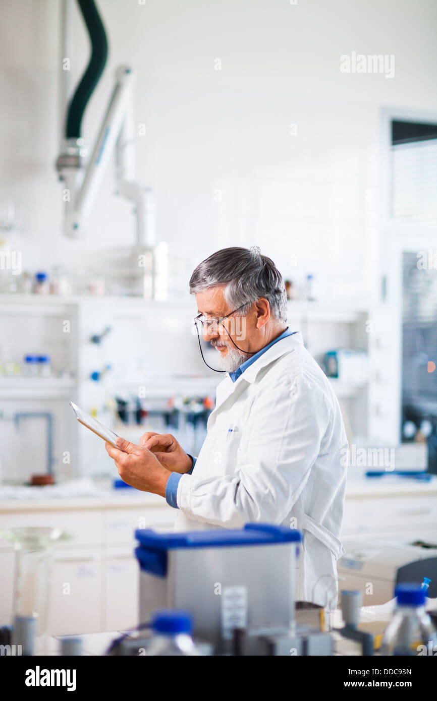 Senior doctor/scientist using his tablet computer at work Stock Photo ...
