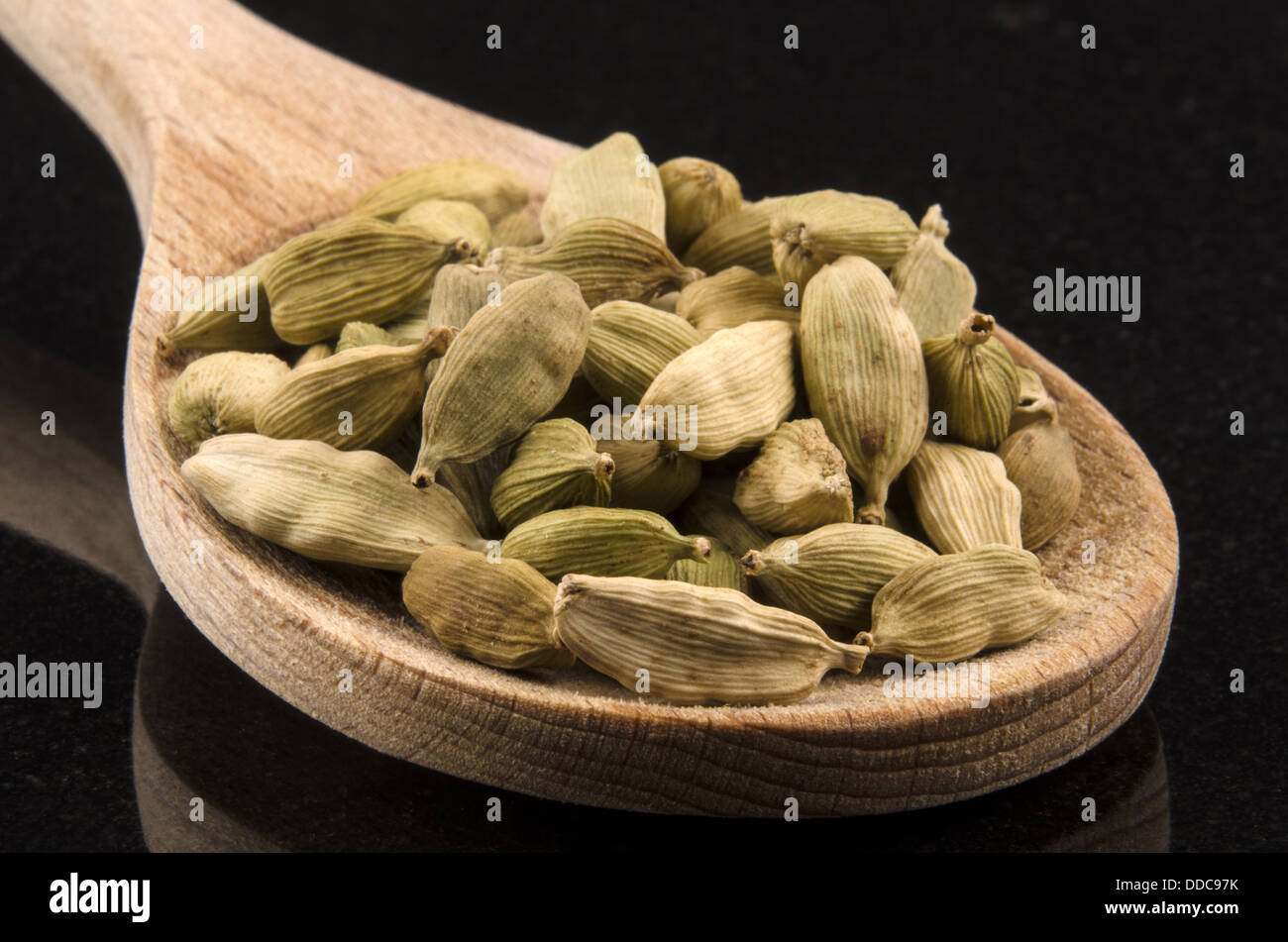 whole cardamom on a kitchen spoon Stock Photo - Alamy