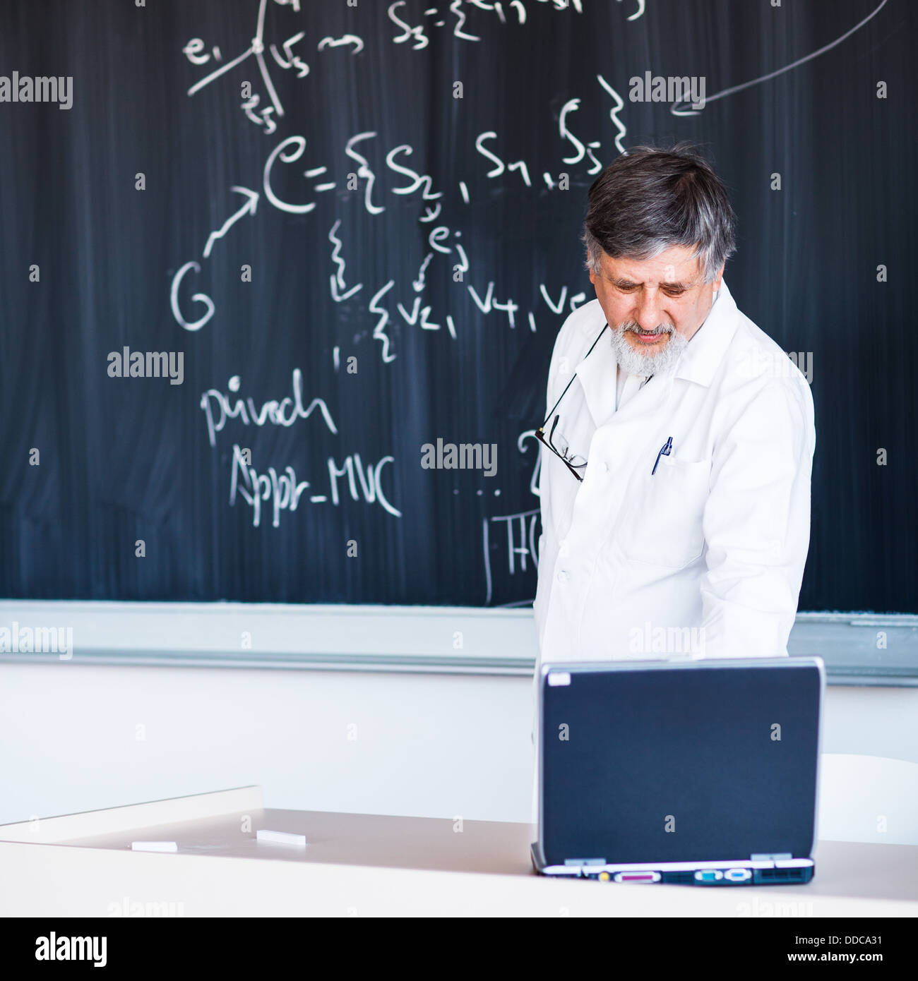 Senior chemistry professor writing on the board while having a c Stock ...