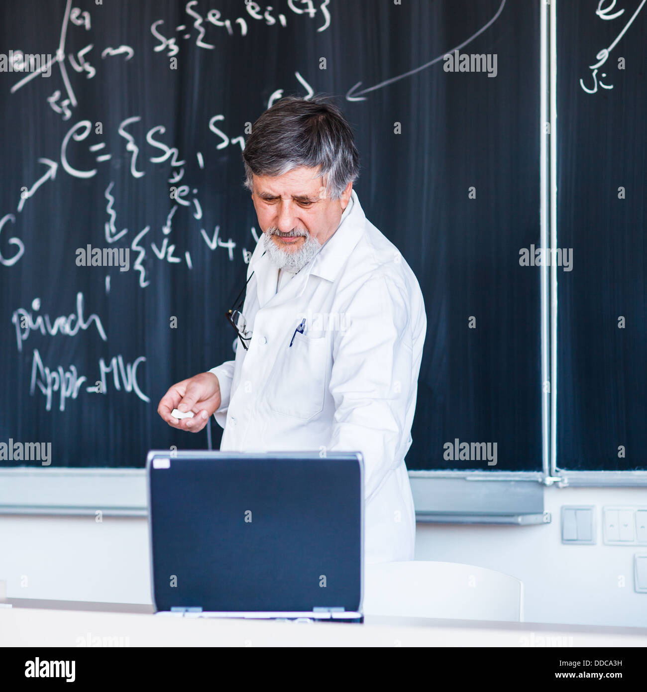 Senior chemistry professor writing on the board while having a c Stock ...