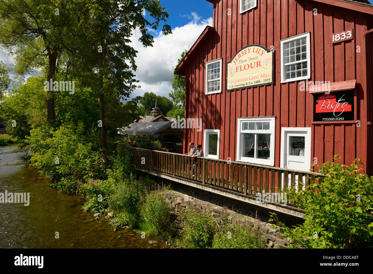 Summer visitors at the restored Coldwater Grist Mill with the flowing ...