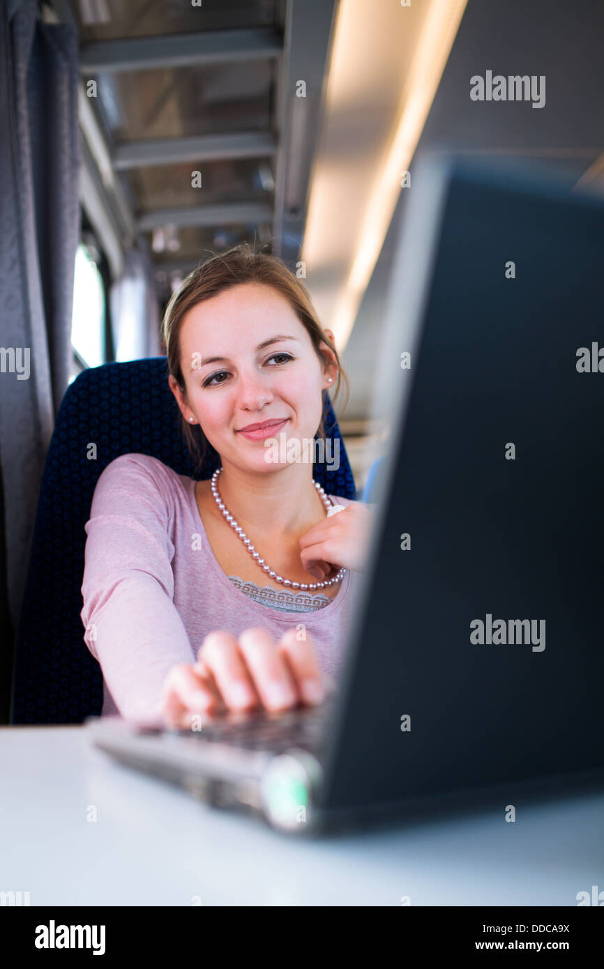 Young woman using her laptop computer while on the train Stock Photo ...