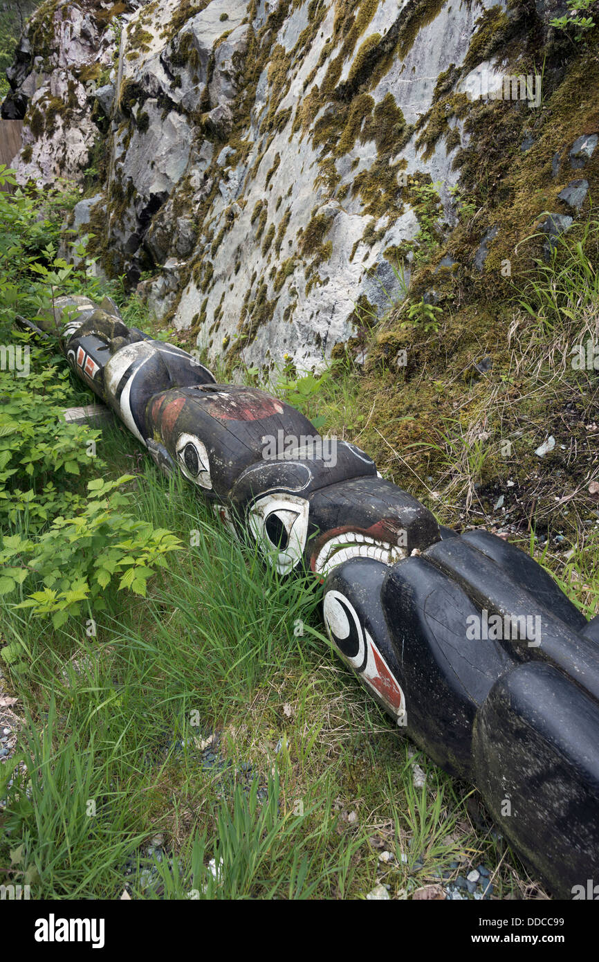 Totem pole lying on the ground behind the 'big house', Klemtu, British ...