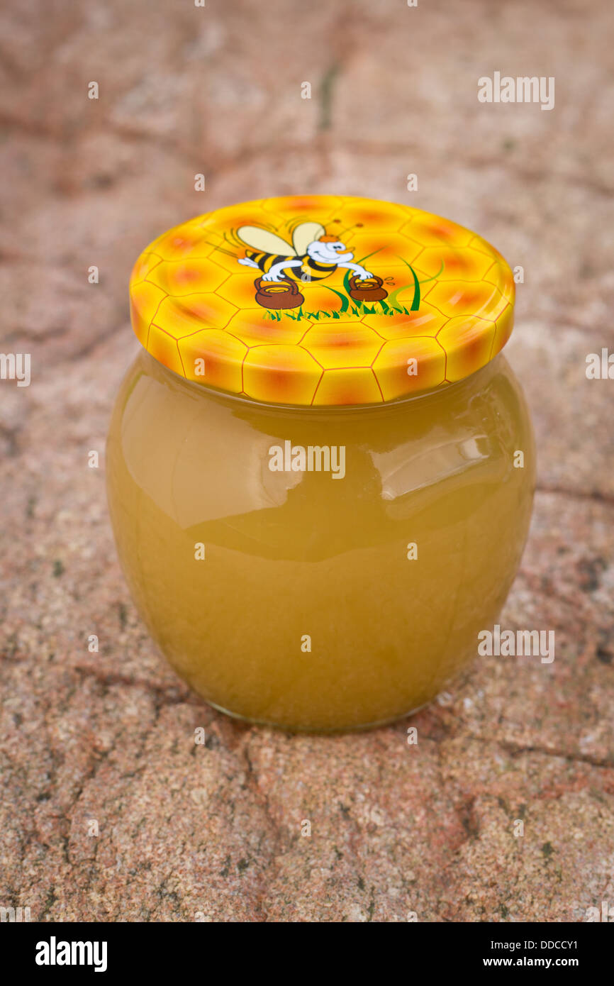 Nice gift jar of honey on stone background Stock Photo - Alamy