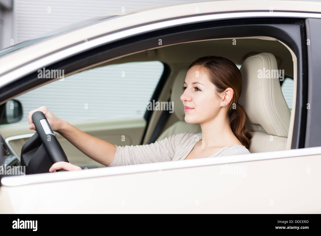 Pretty young woman driving her new car Stock Photo - Alamy