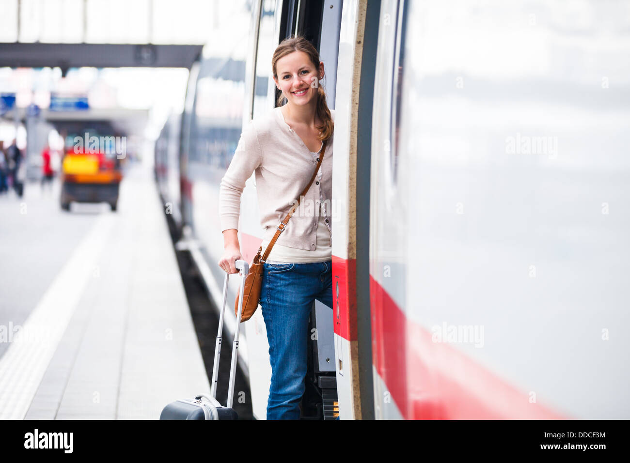 Pretty young woman boarding a train Stock Photo - Alamy