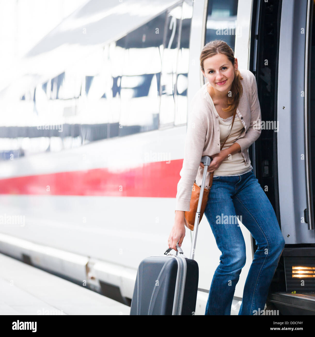 Pretty young woman boarding a train Stock Photo - Alamy