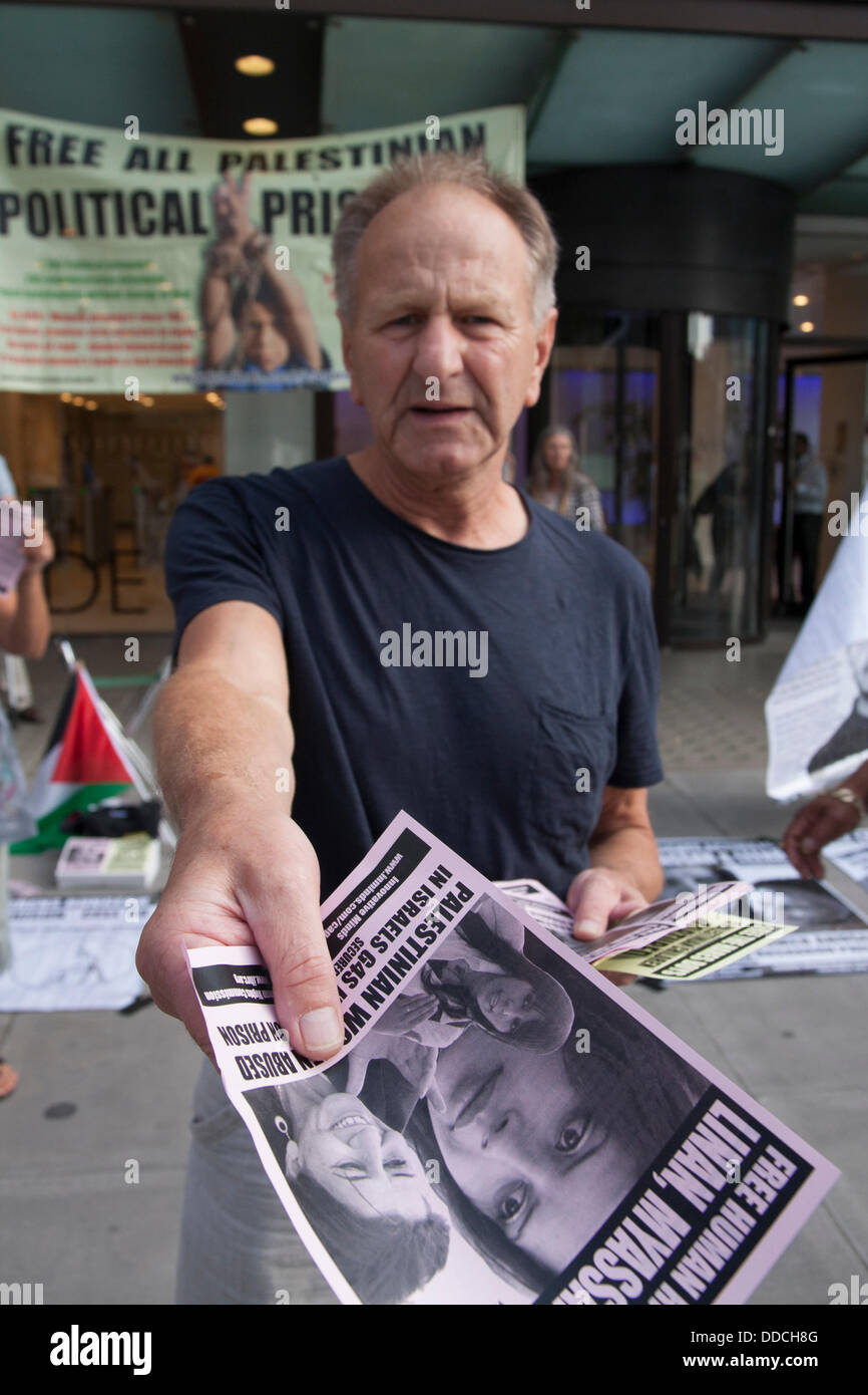 London, UK. 30th Aug, 2013. An activist hands out leaflets as a small ...