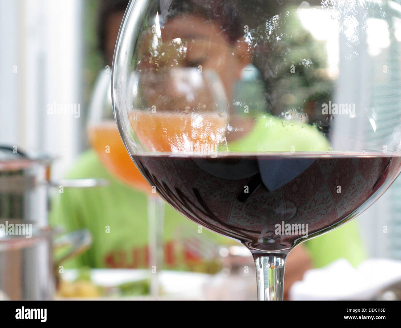 A blurred figure sits behind a half-filled glass Stock Photo - Alamy