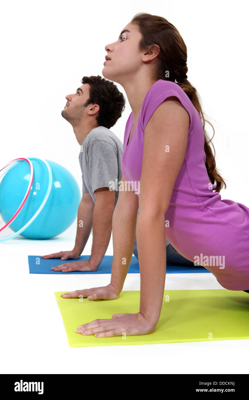 Couple doing yoga on mat Stock Photo - Alamy