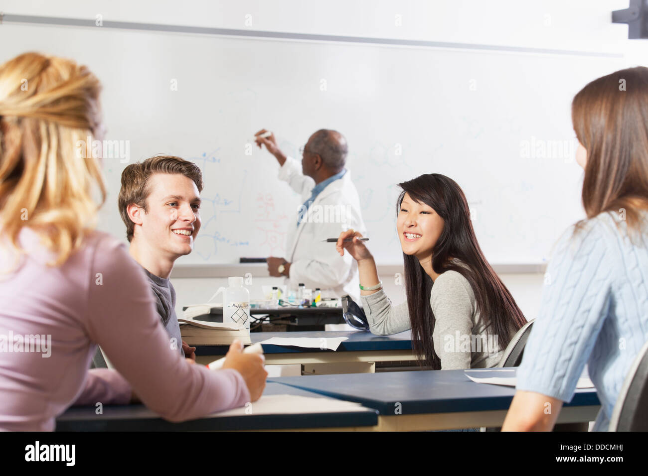 Students talking in an engineering class while the professor is writing ...