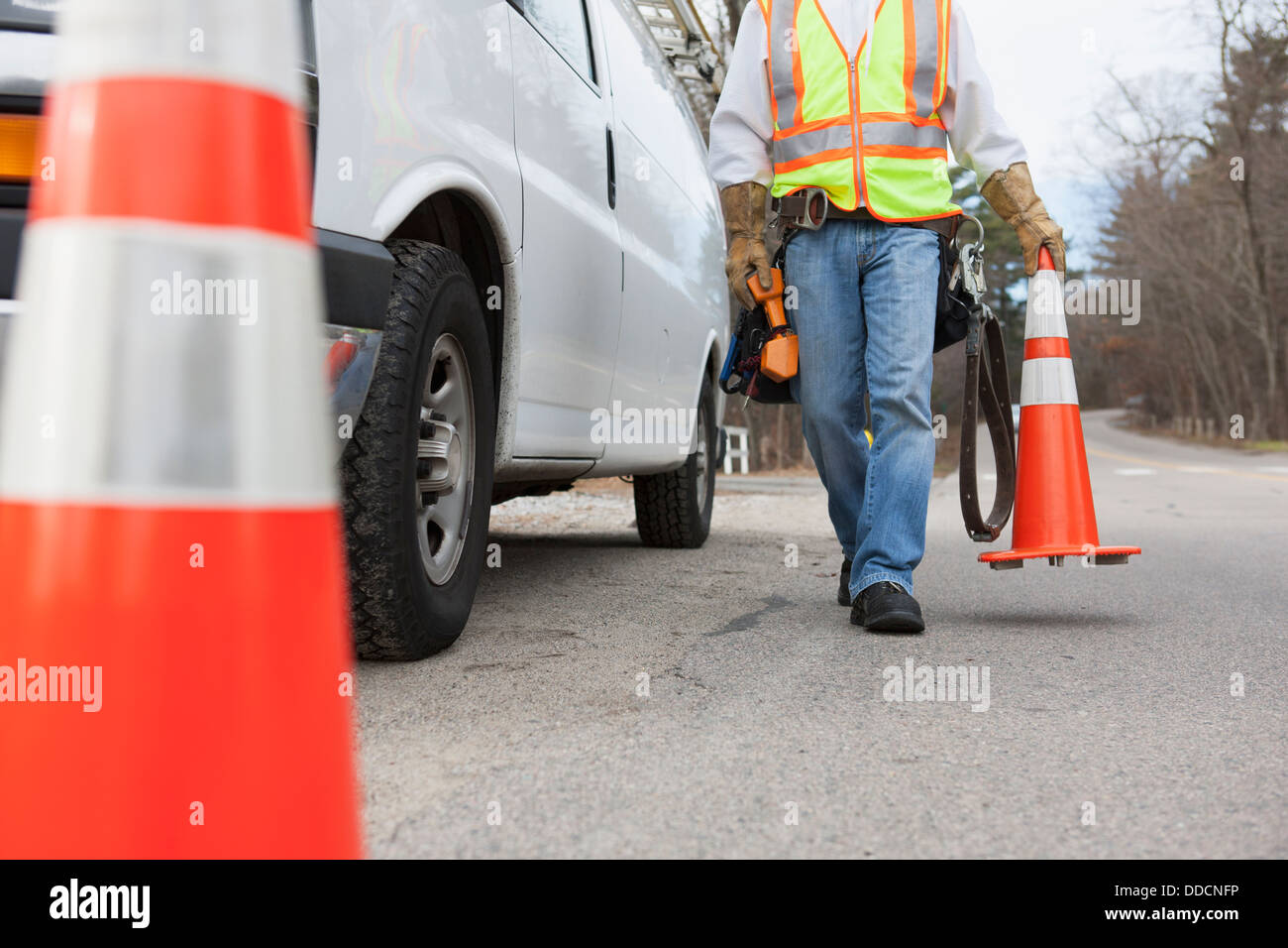 Communications worker placing traffic cones around his truck Stock ...