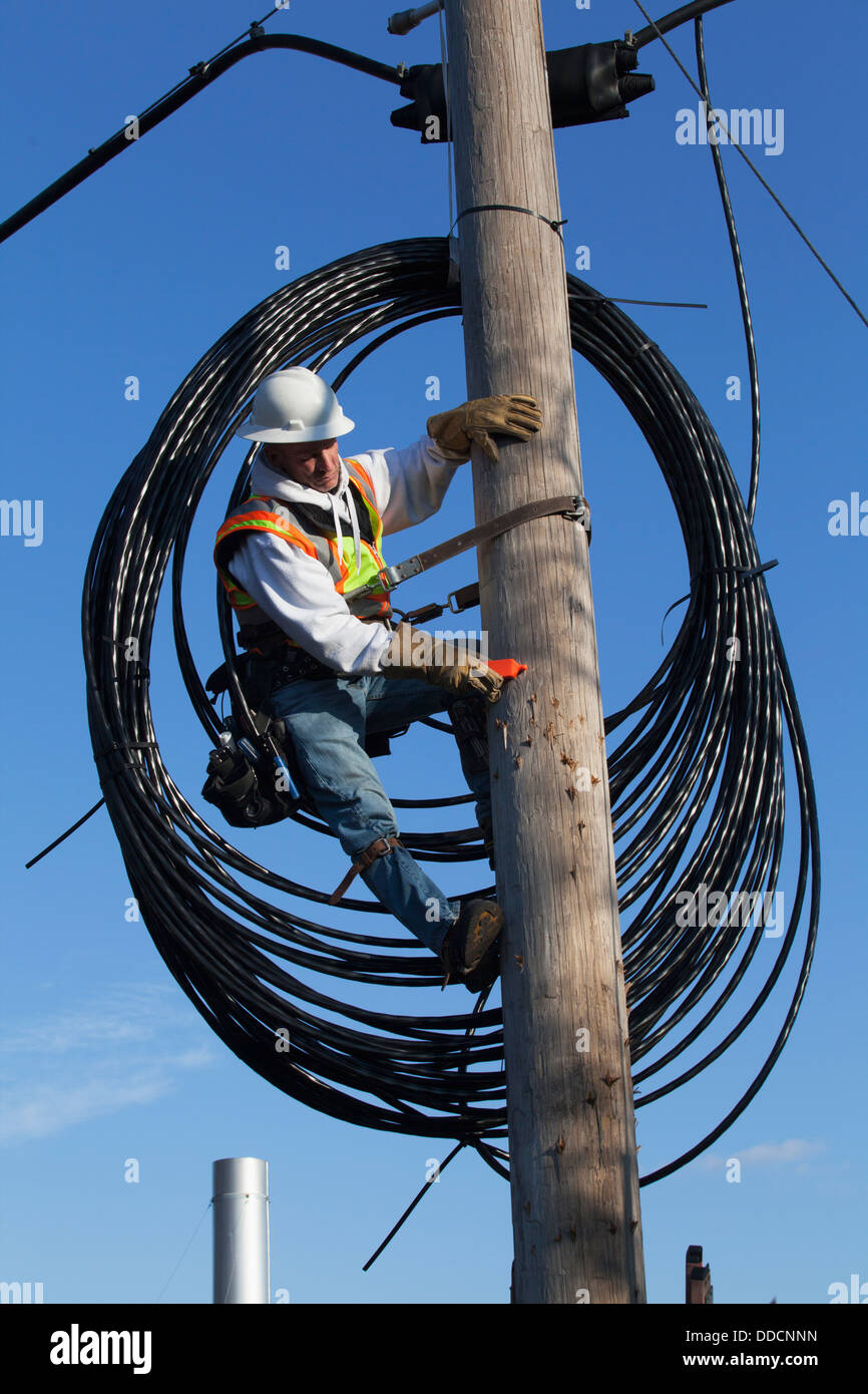 Cable lineman preparing to install new cable from power pole Stock ...