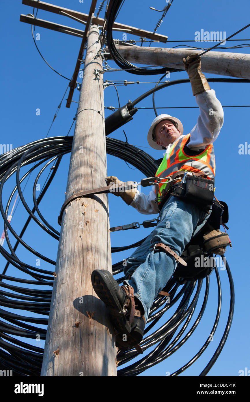 Cable lineman checking support wire tension for new cable installation ...