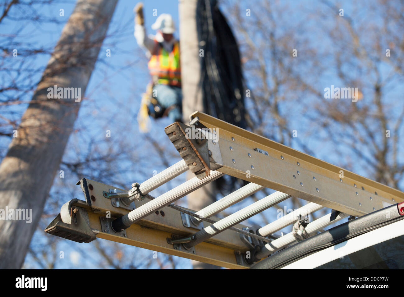 Ladder on a truck and lineman working on power pole Stock Photo - Alamy