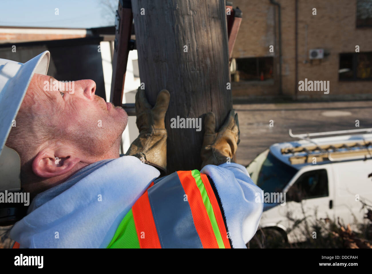 Cable lineman on a power pole looking at installed cables Stock Photo ...