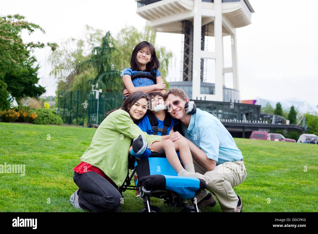 Disabled boy in wheelchair surrounded by family Stock Photo - Alamy