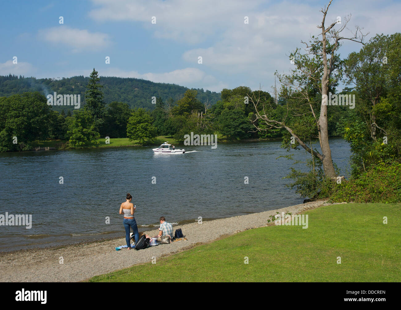 Young couple relaxing on beach, Cockshott Point, Lake Windermere ...