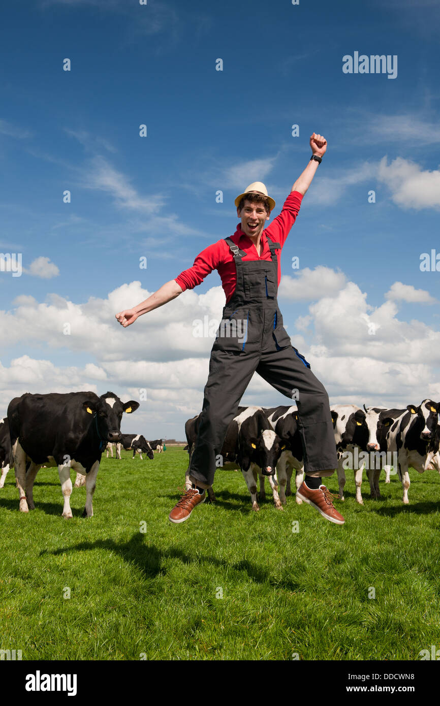 Happy farmer in field with cows Stock Photo - Alamy