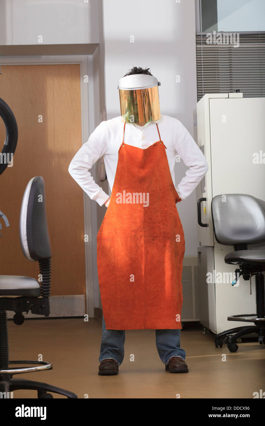 Engineering student wearing leather protective smock and splash guard ...