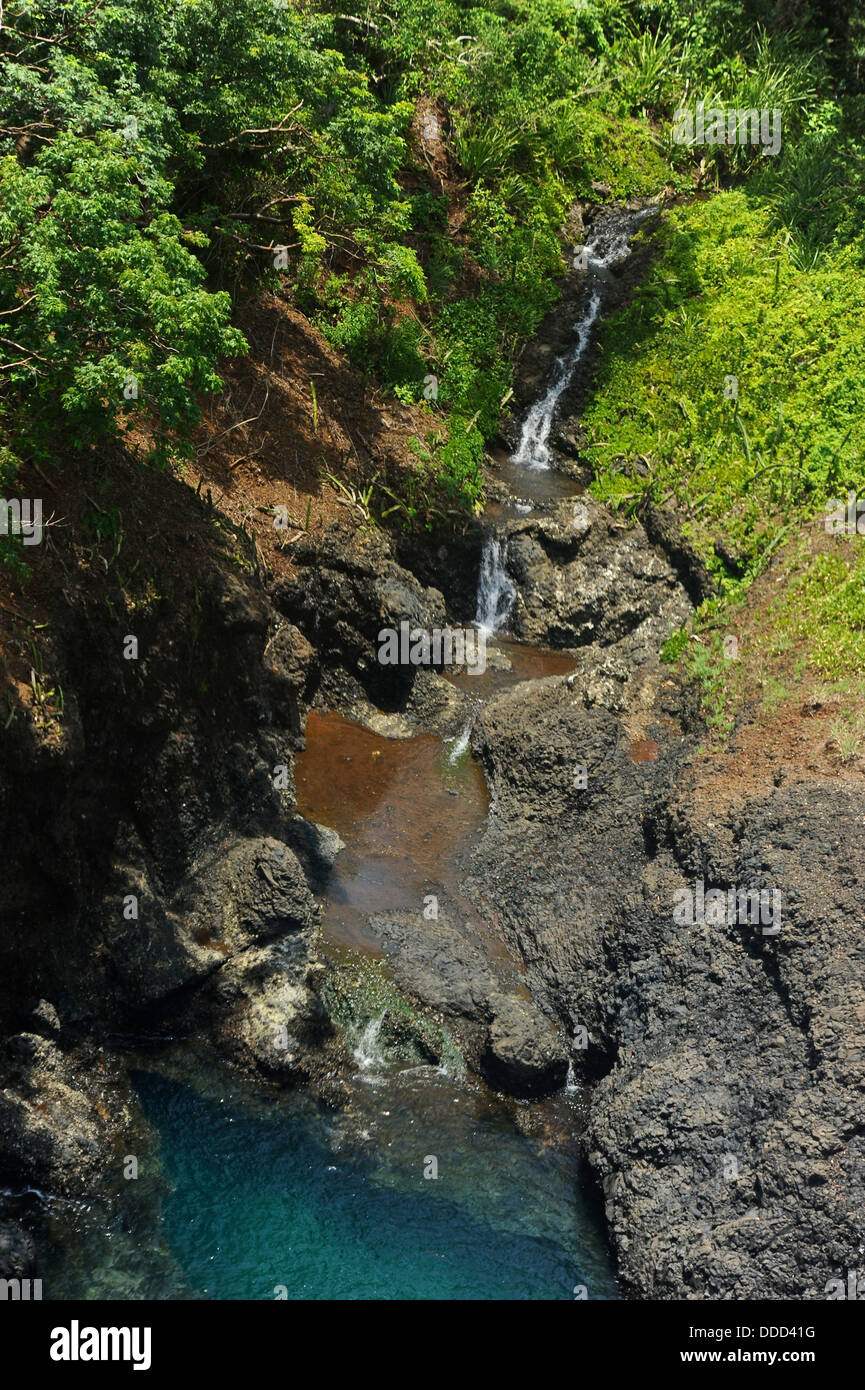A narrow waterfall empties into the clear water of the Pearl Islands ...