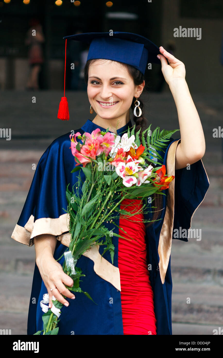 Image of a happy young graduate with flowers Stock Photo - Alamy