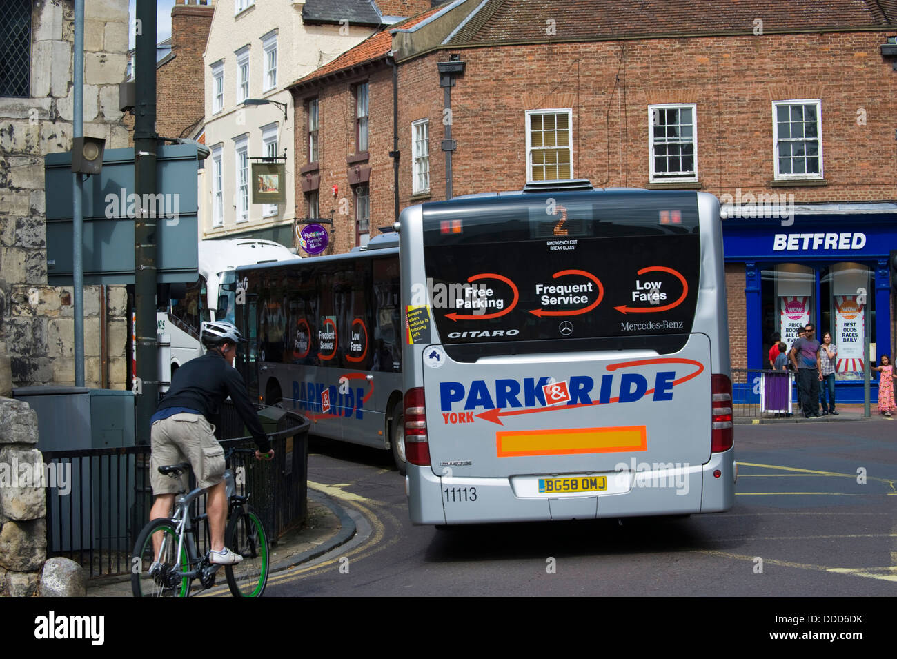 Public transport bendy bus with cyclist in the city centre of York ...