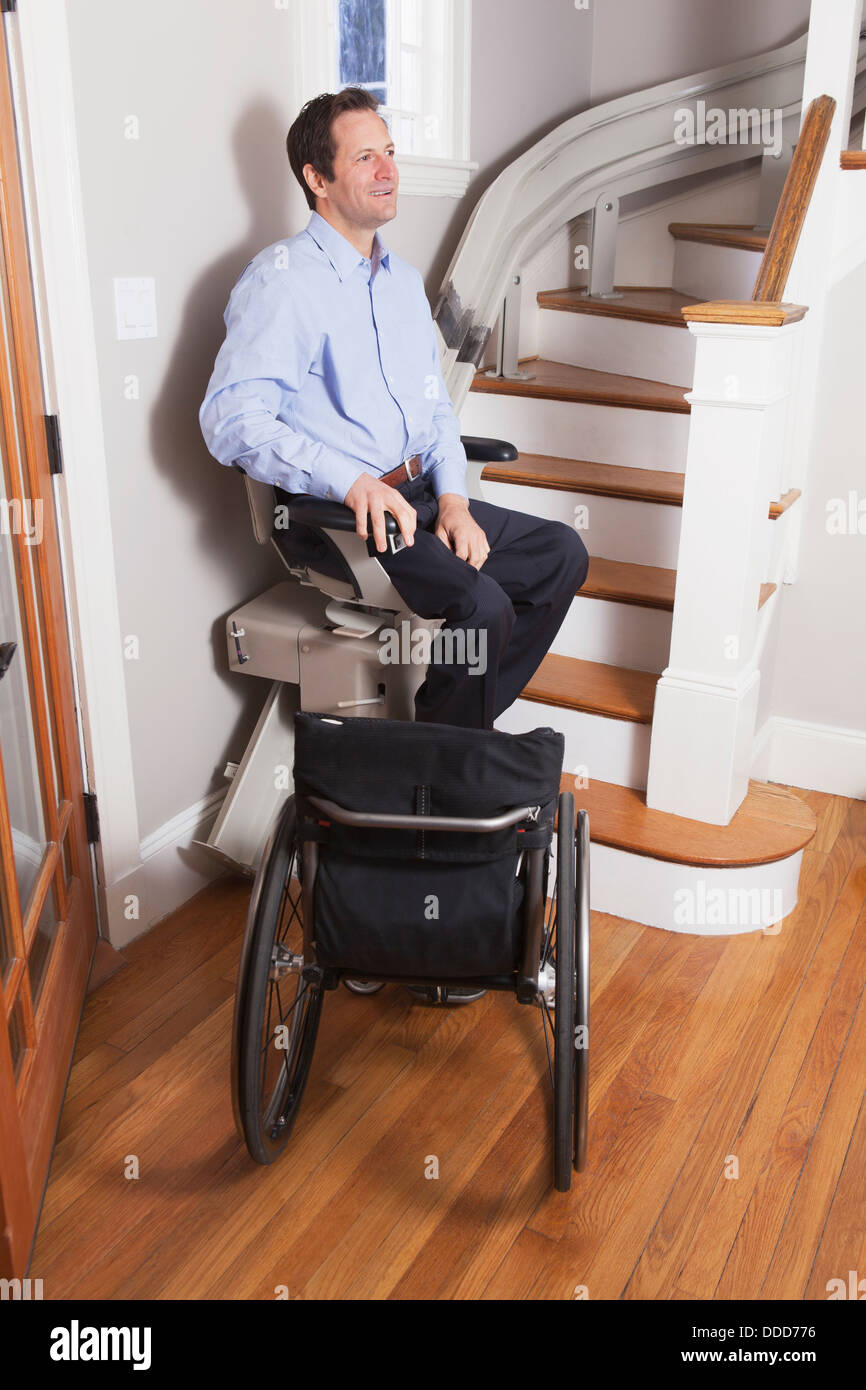Man with spinal cord injury going up in his motorized stair lift Stock ...